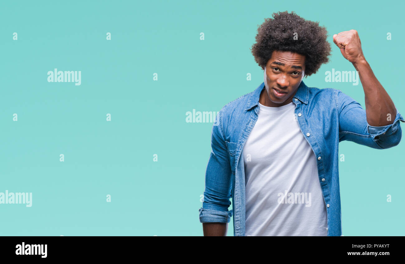 Afro american man over isolated background angry and mad raising fist ...