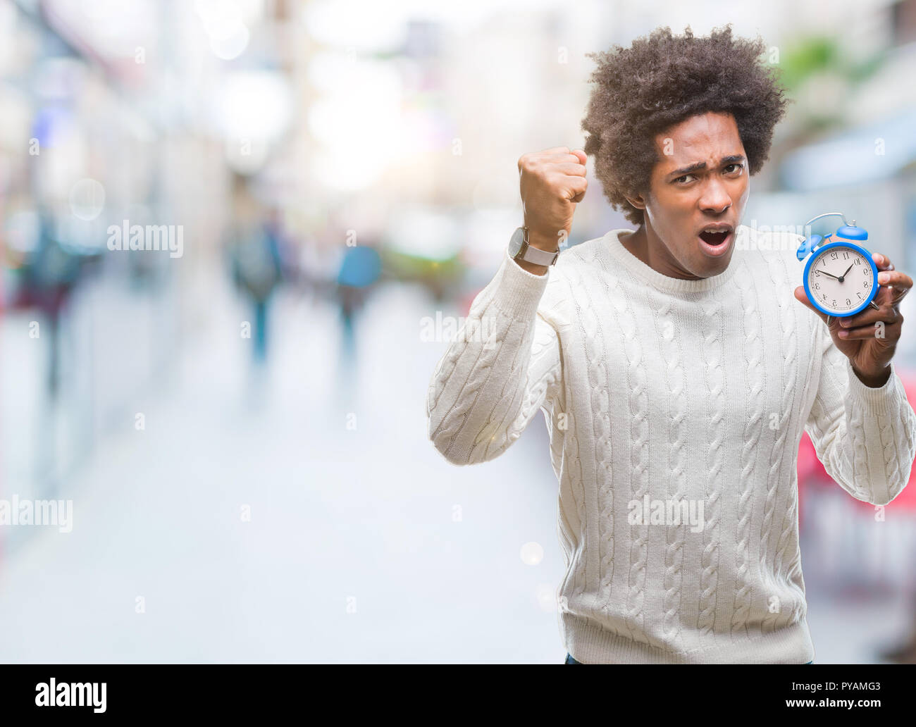 Afro american man holding vintage alarm clock over isolated background ...