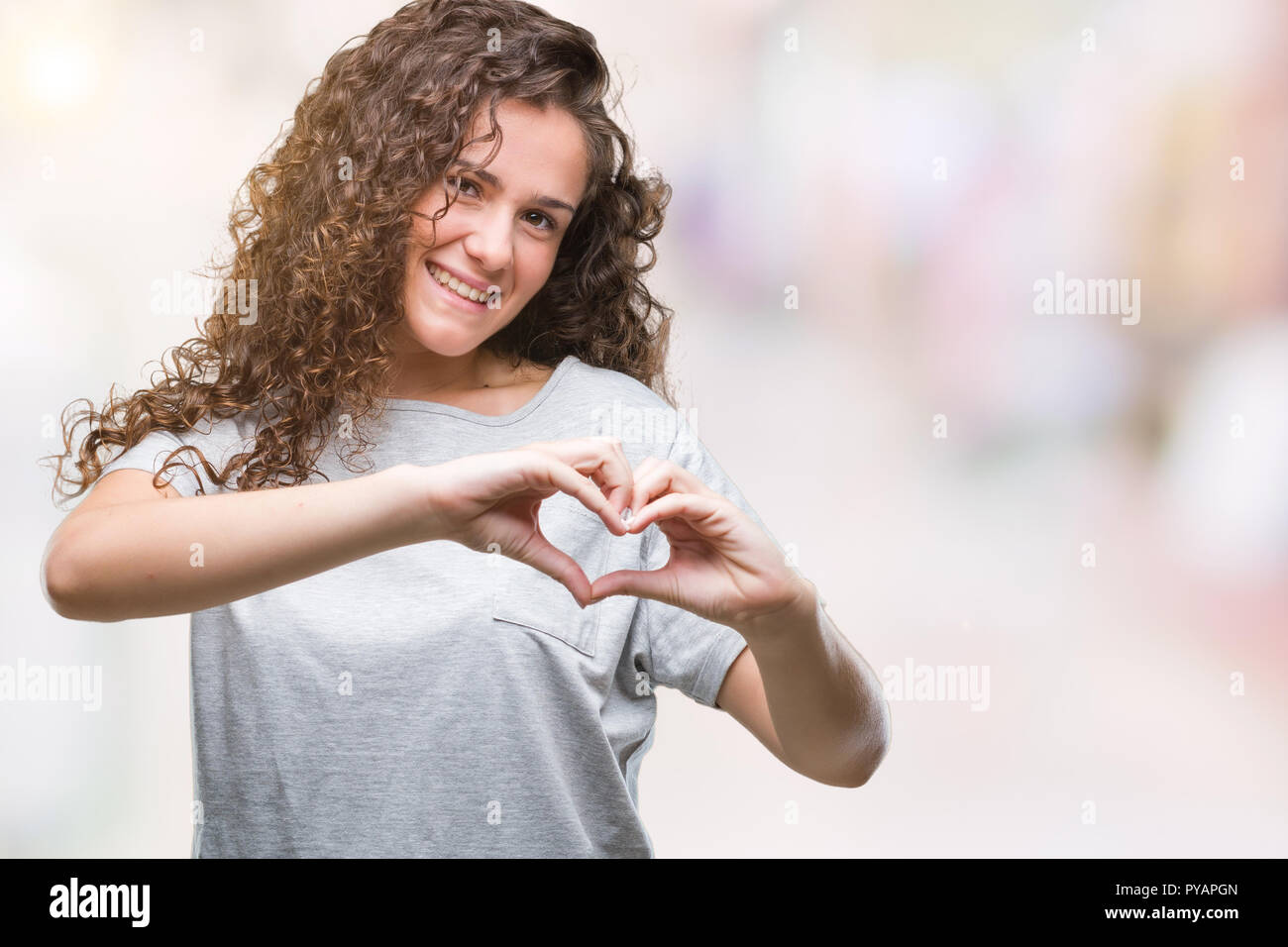 Beautiful young brunette curly hair girl wearing casual look over ...