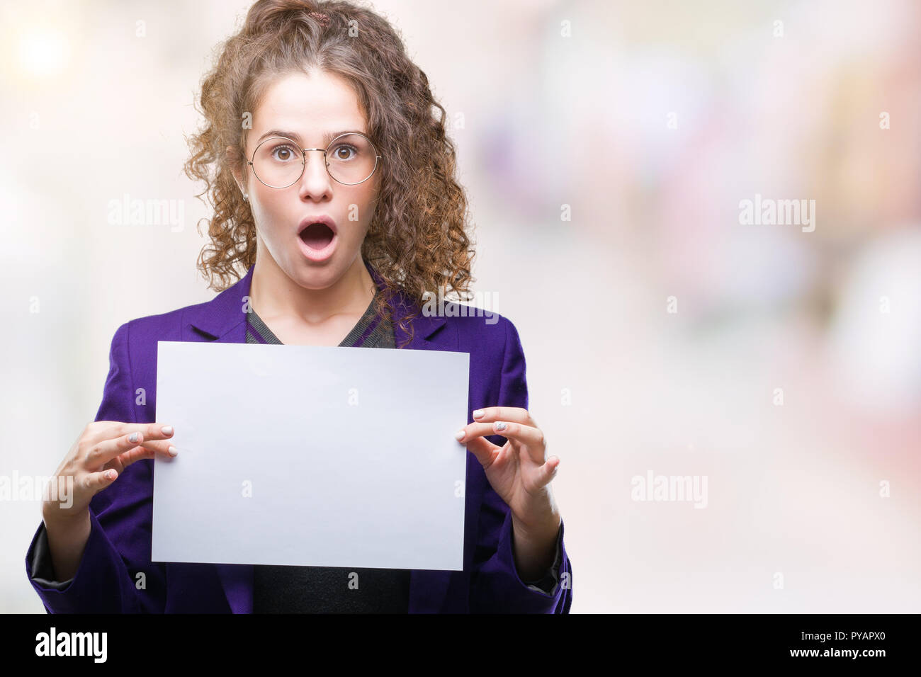 Young brunette student girl wearing school uniform holding blank paper ...