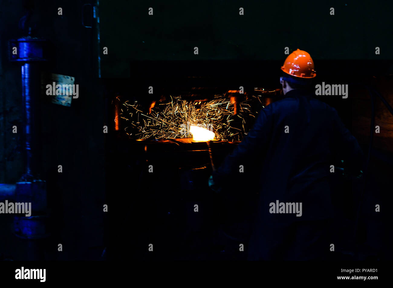 Industrial Worker at the factory welding closeup. Hot iron in smeltery ...