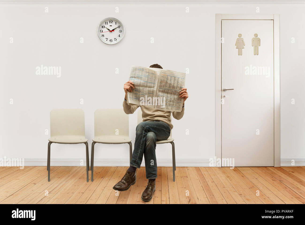 waiting room with a seated person reading newspaper Stock Photo - Alamy