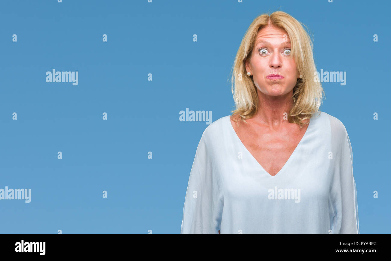 Middle age blonde business woman over isolated background puffing ...