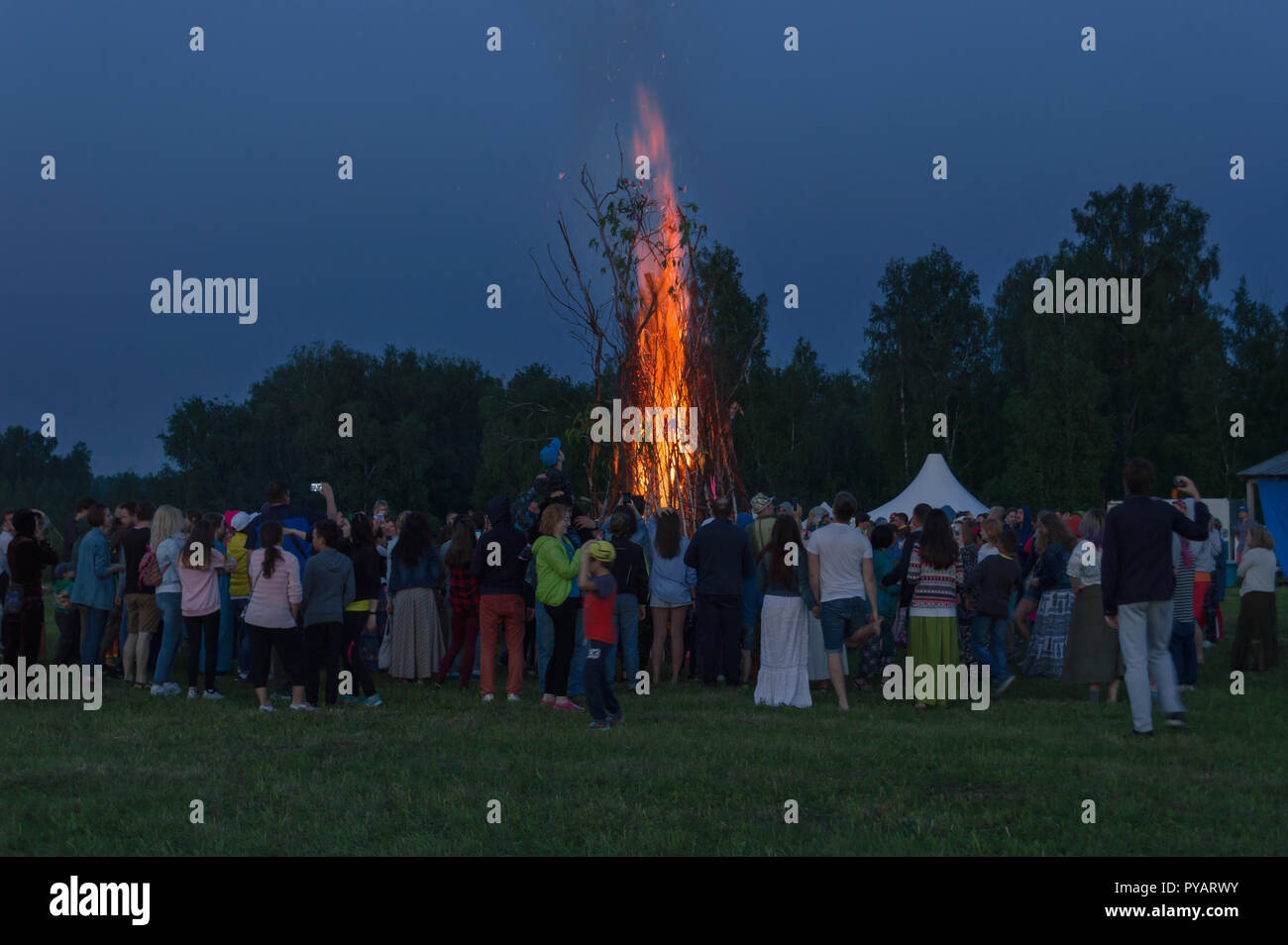 people gathering around big bonfire at the end of the solstice festival ...