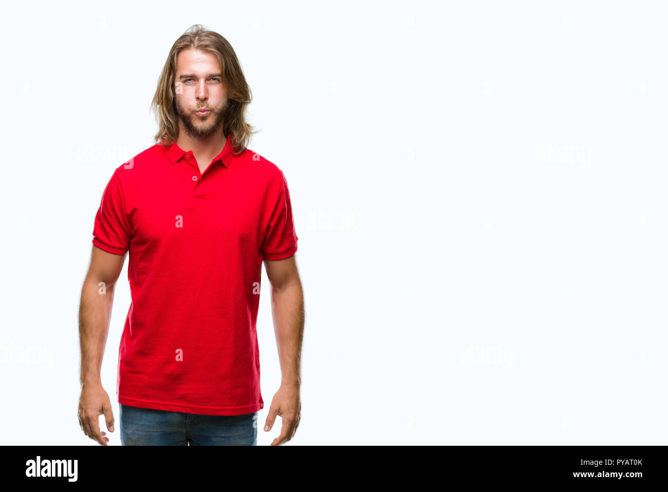 Young handsome man with long hair over isolated background puffing ...