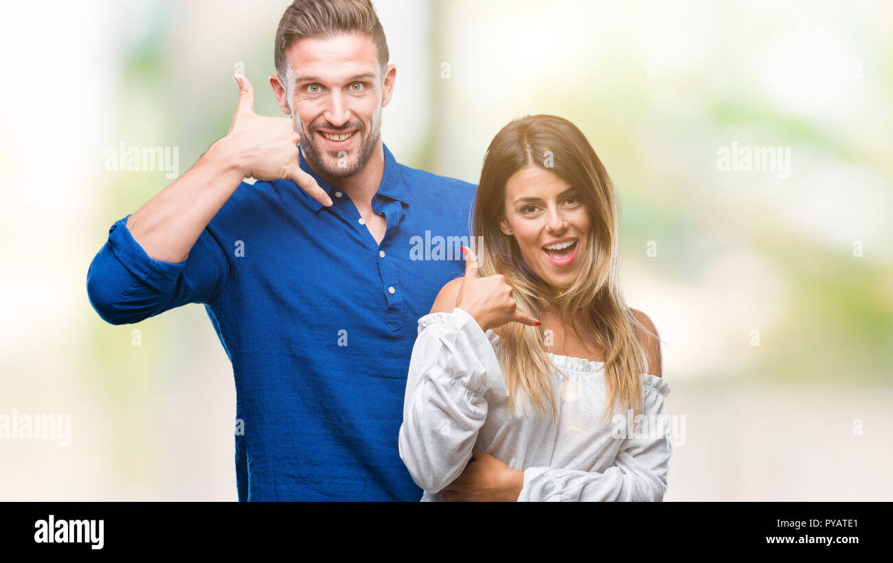 Young couple in love over isolated background smiling doing phone ...
