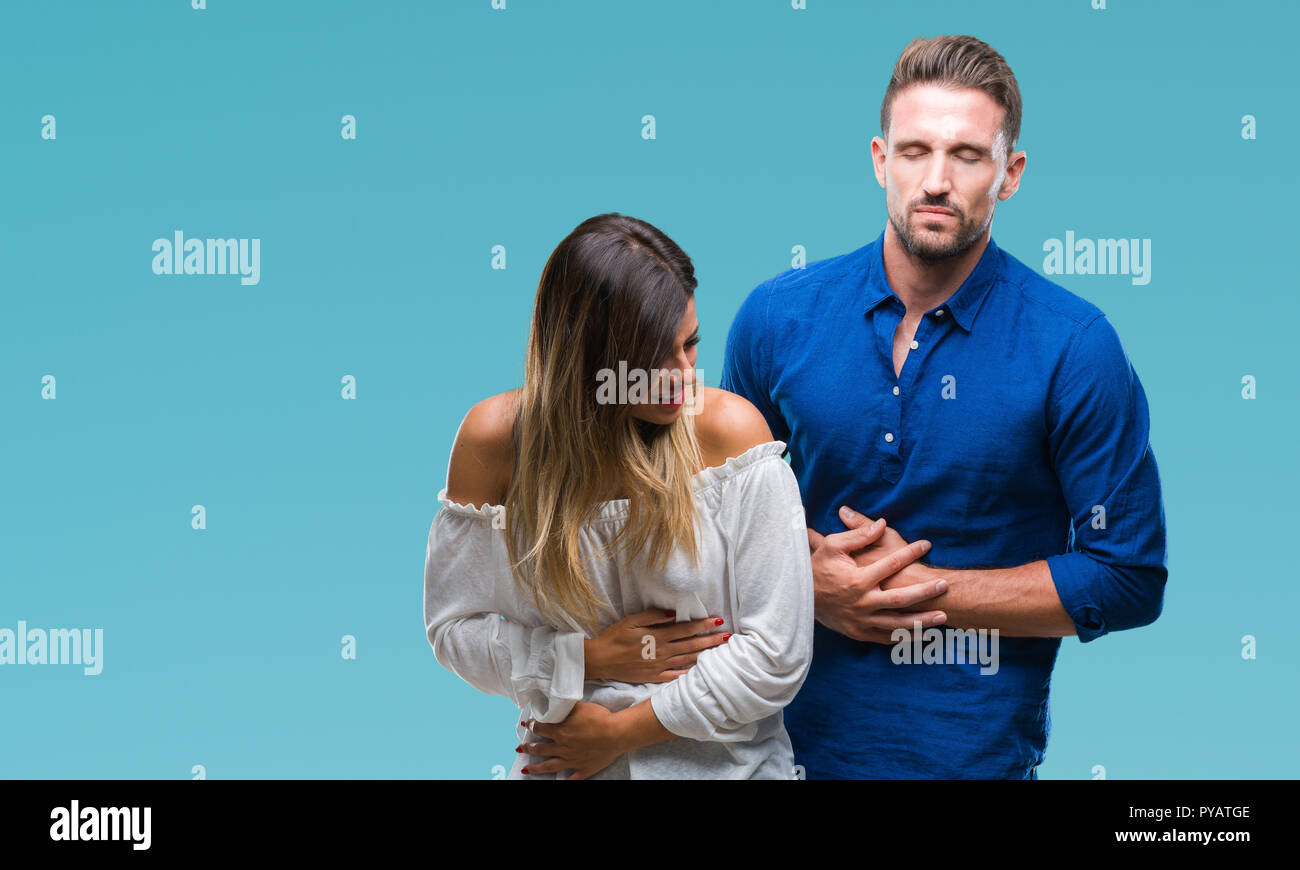 Young couple in love over isolated background with hand on stomach ...
