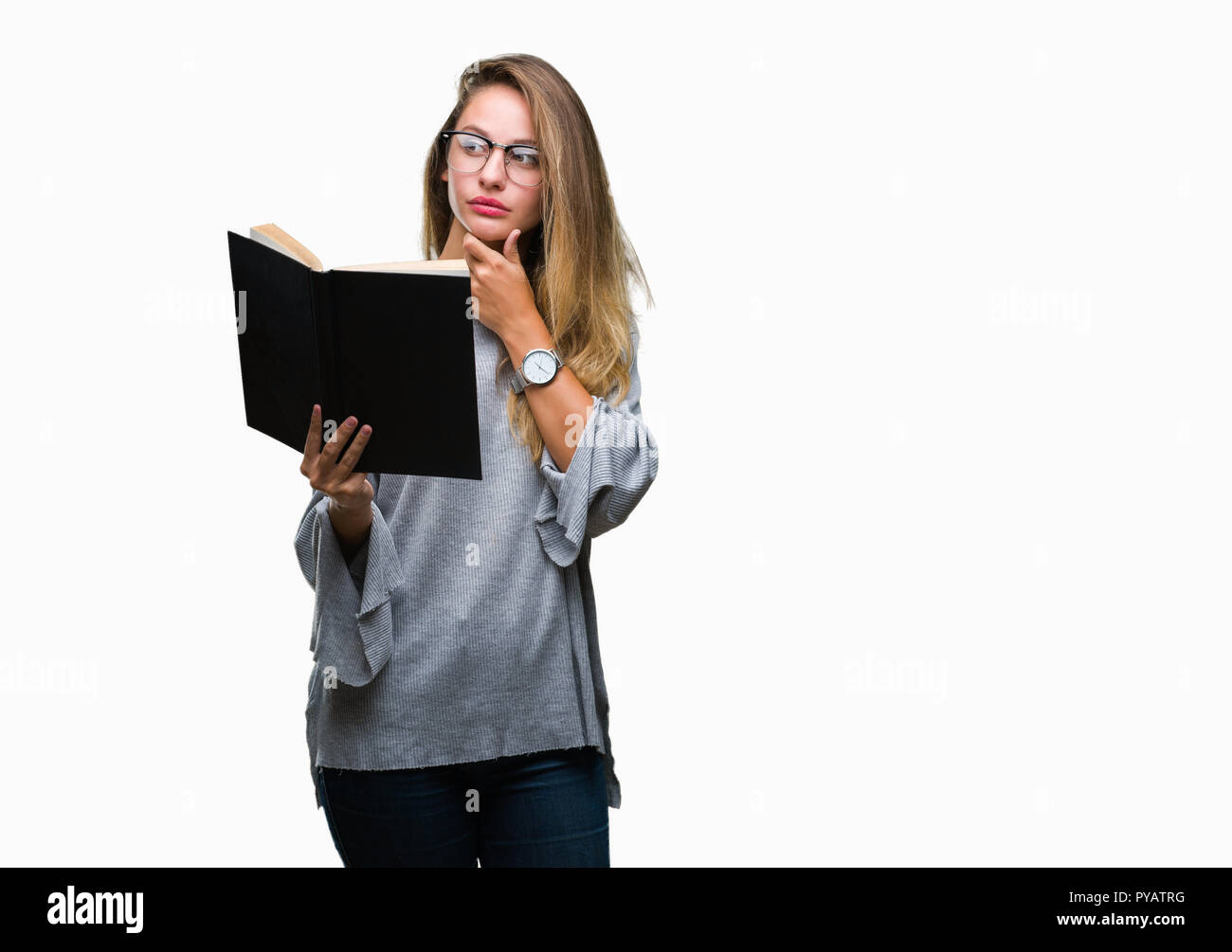Young beautiful blonde woman reading a book over isolated background ...