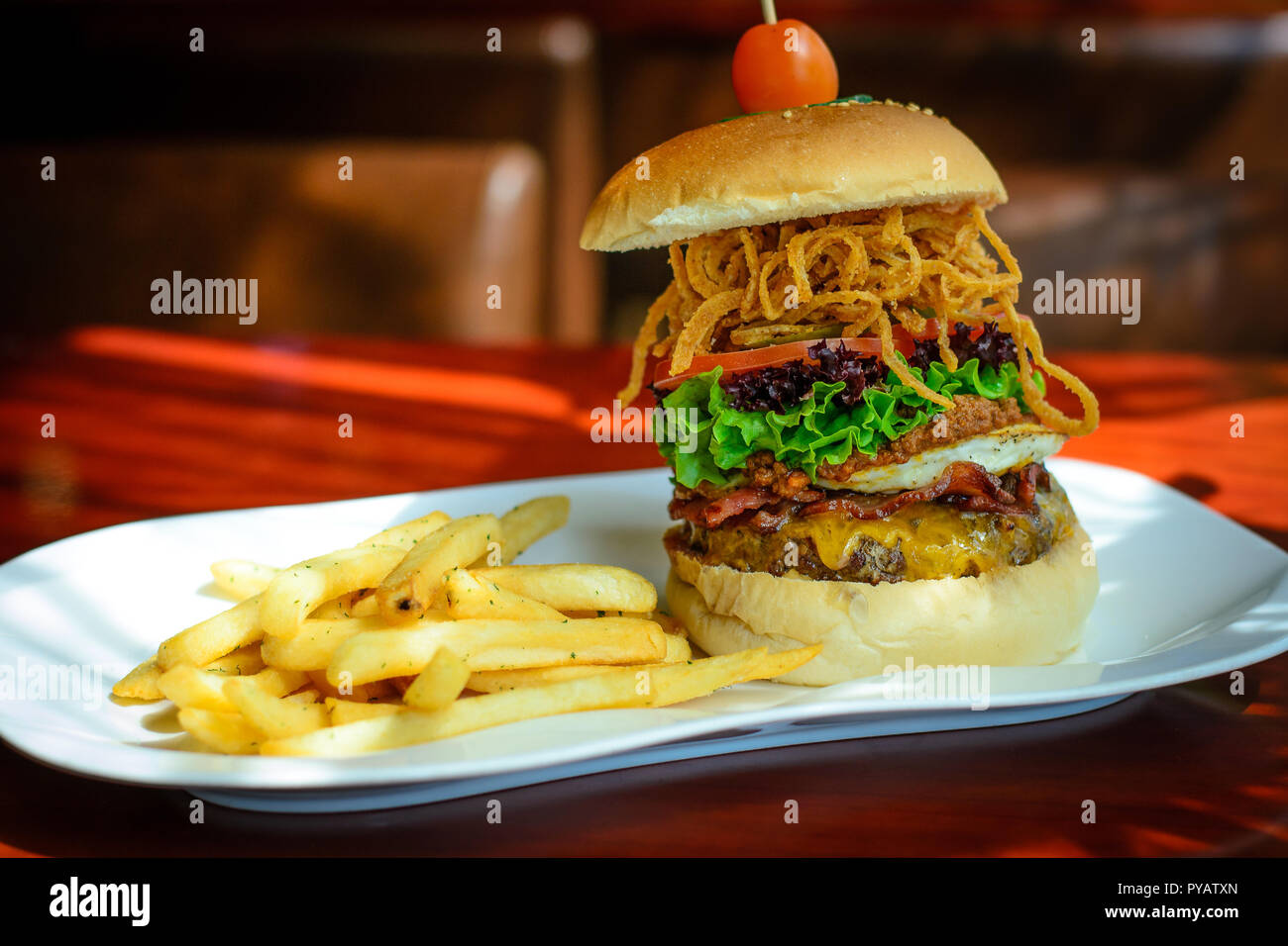 burger with beef patty, bacon, cheddar cheese, egg, chilli, lettuce ...