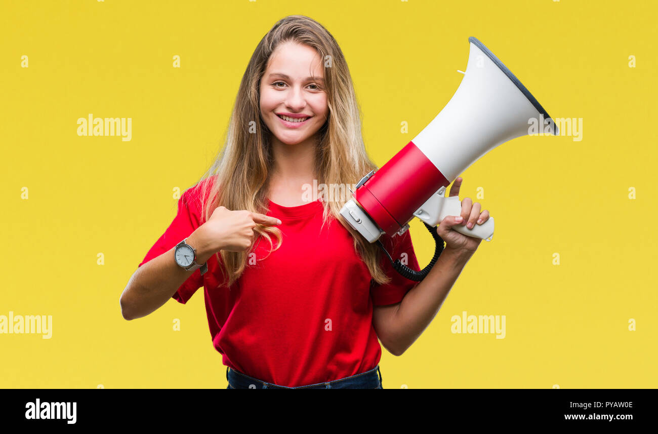 Young beautiful blonde woman yelling through megaphone over isolated ...