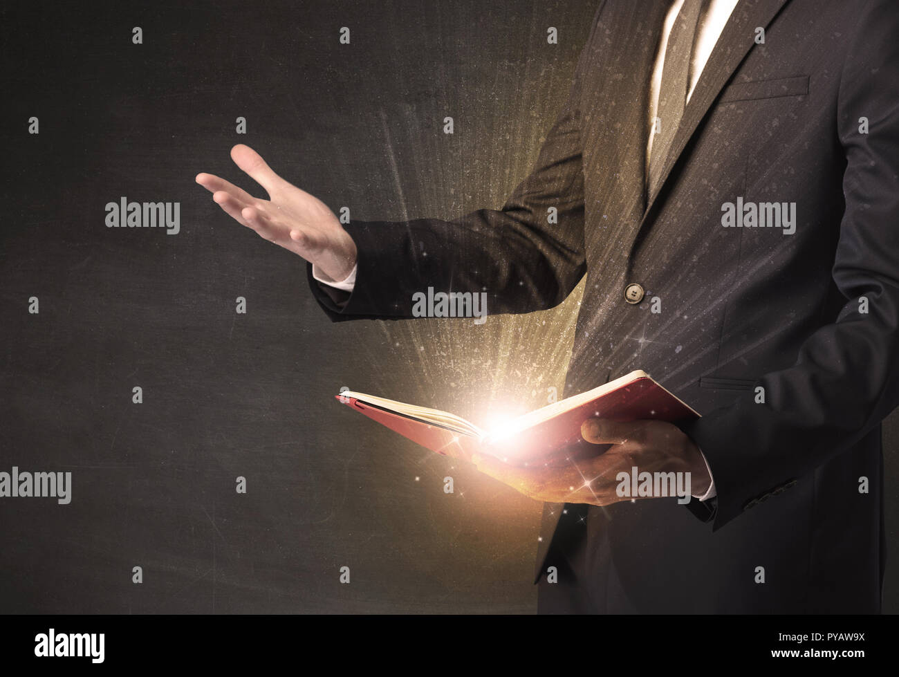 Man holding and reading a shiny book Stock Photo - Alamy