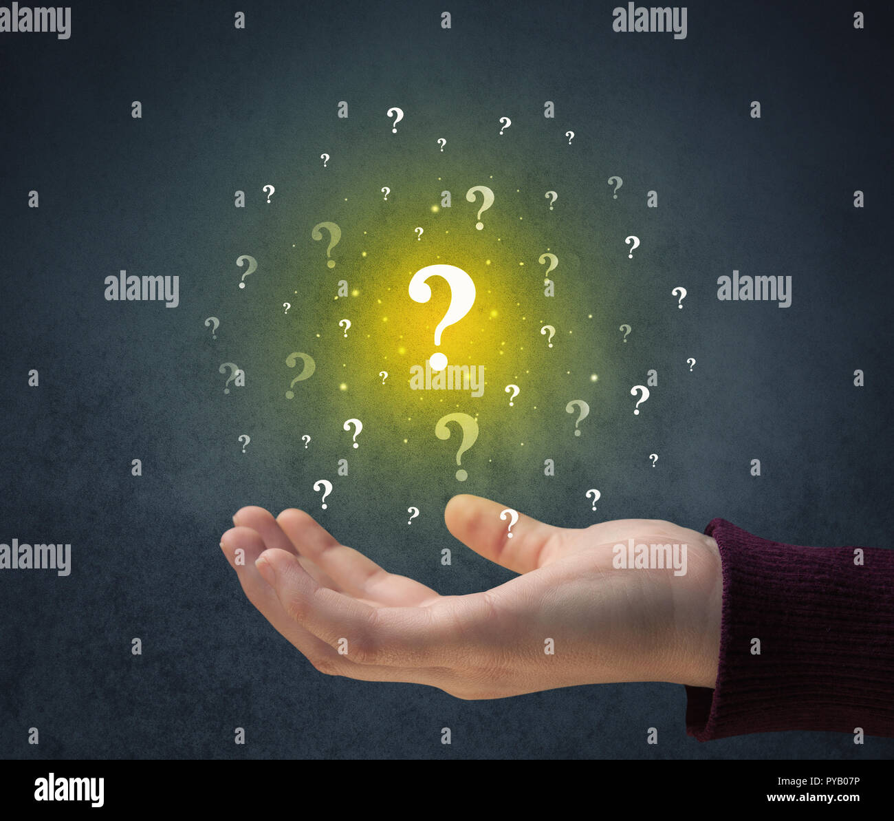 Yellow question marks hovering over young hand Stock Photo - Alamy