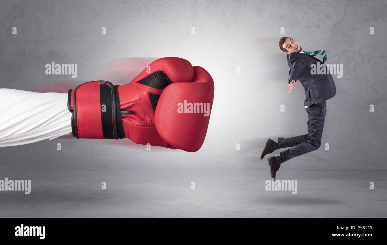 Businessman gets a hit from a giant hand with boxing gloves Stock Photo ...