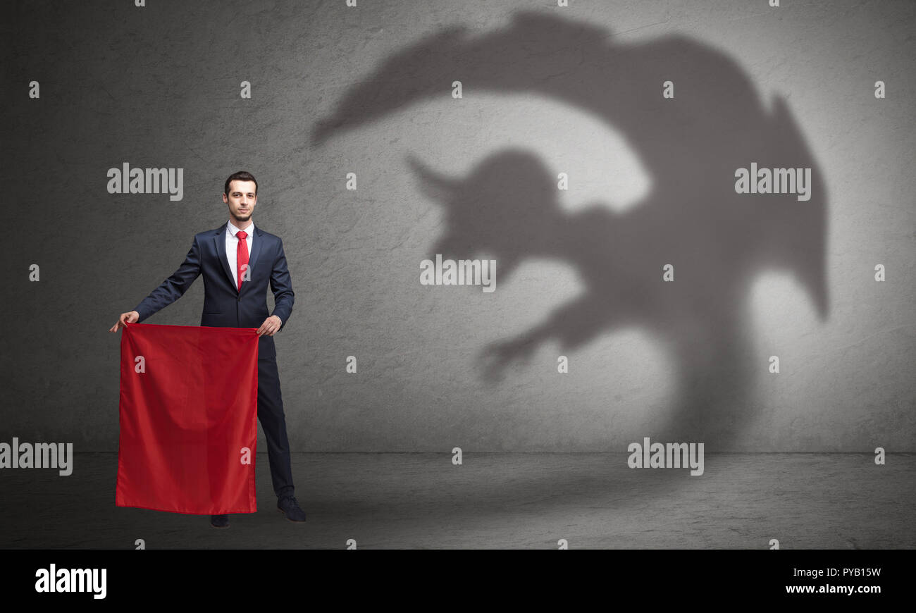 Businessman standing with red cloth in his hand and imp shadow on the ...