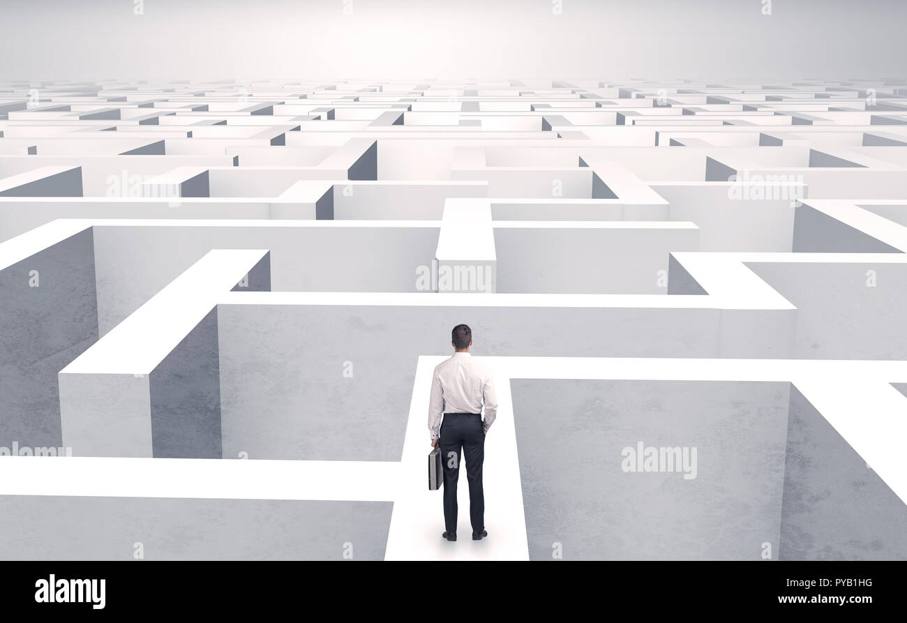Small businessman in a middle of a huge maze Stock Photo - Alamy