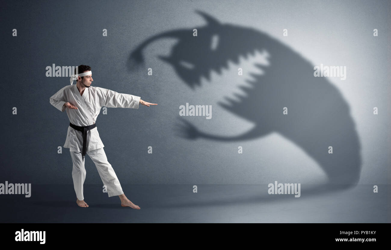 Young karate man fighting with a big black scary shadow Stock Photo - Alamy