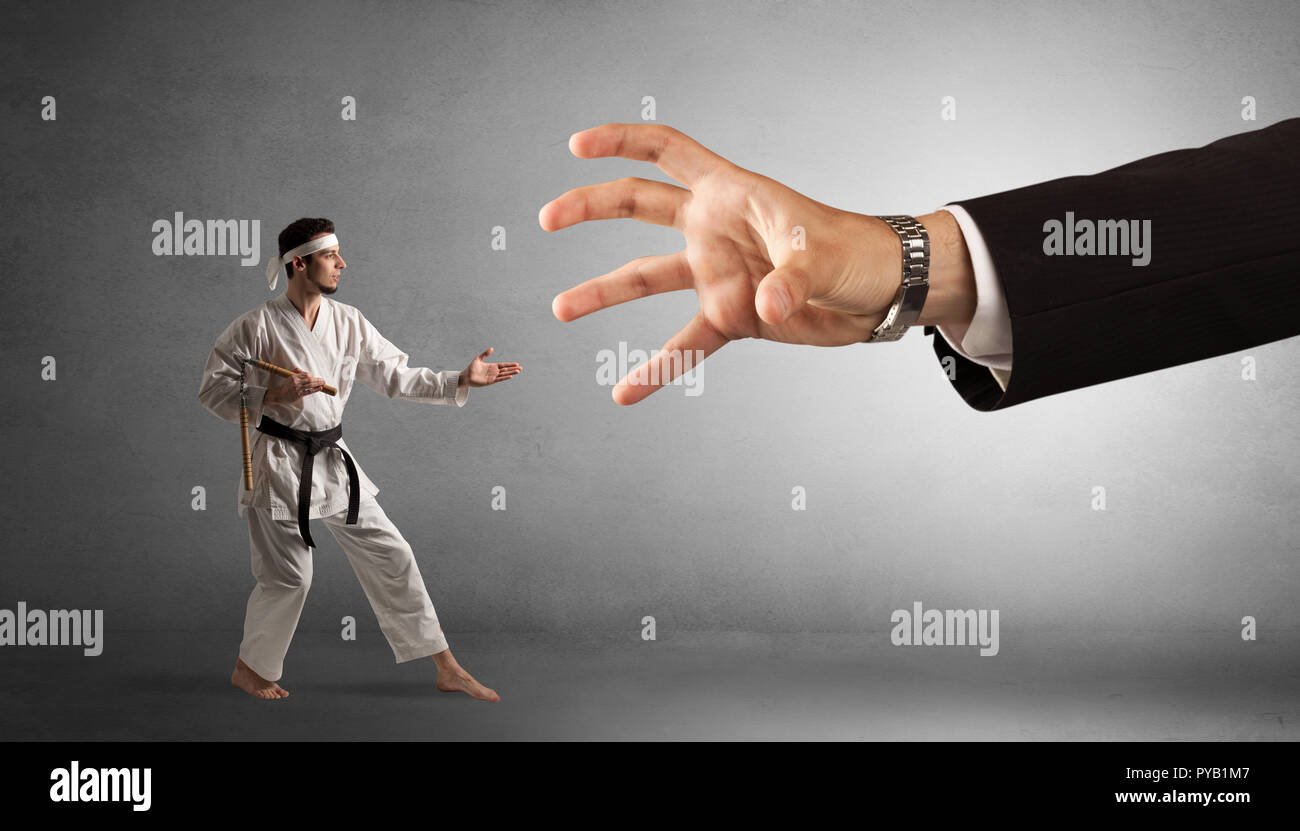 Small karate man fighting with big hand Stock Photo - Alamy