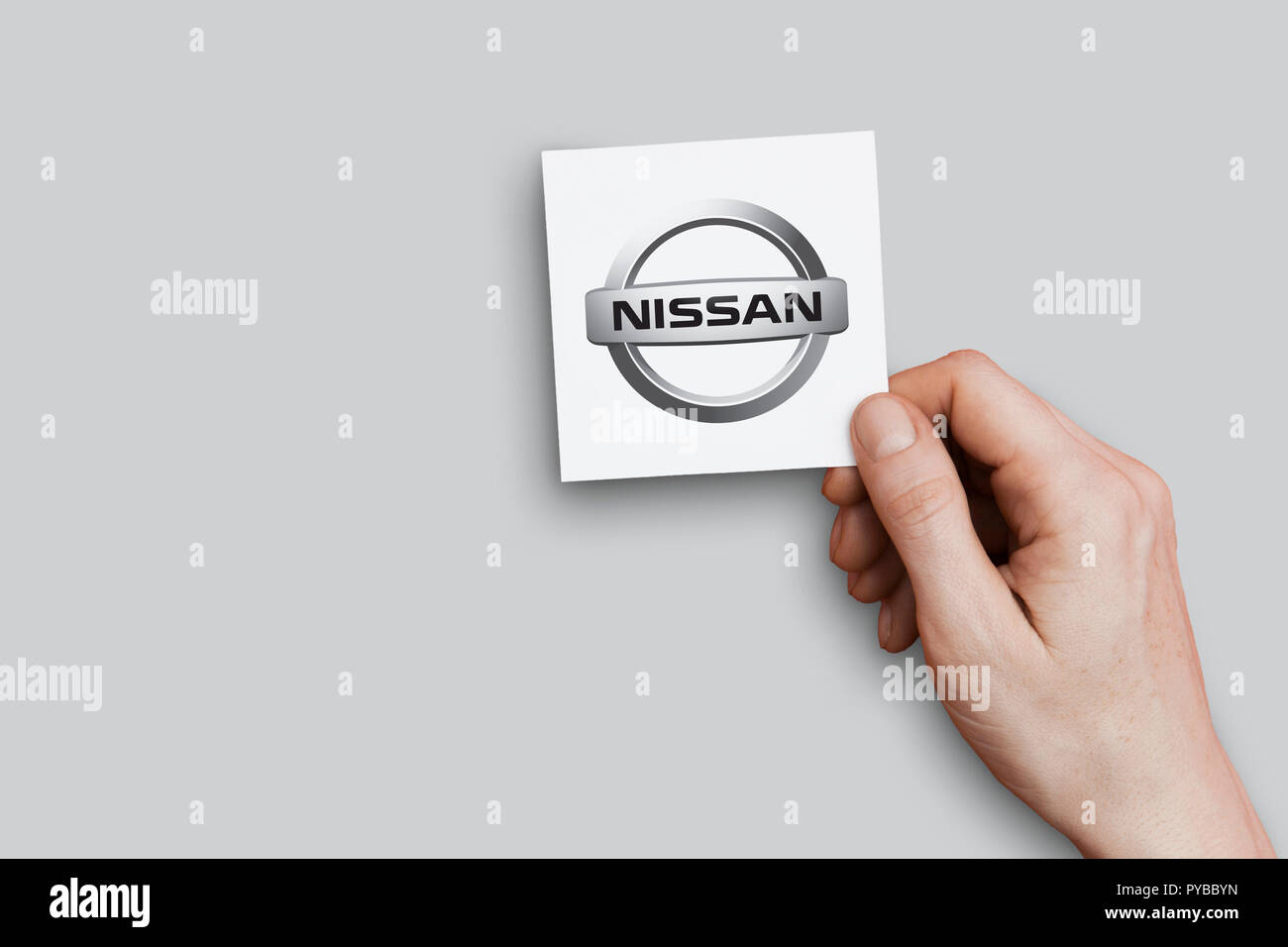LONDON, UK - October 26th 2018: Hand holding a Nissan logo. Nissan is ...