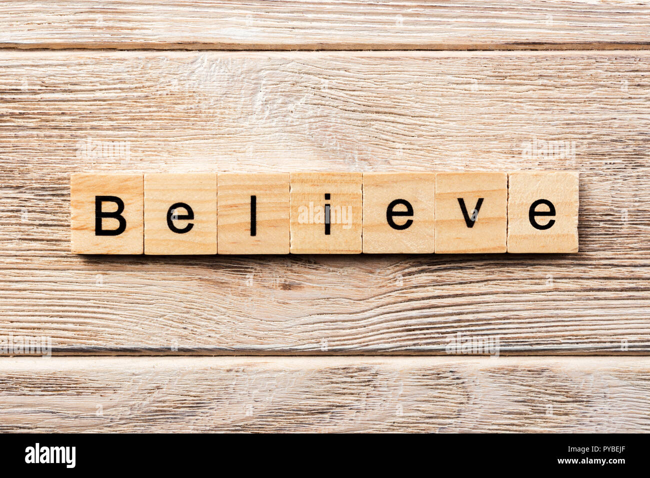 believe word written on wood block. believe text on table, concept ...