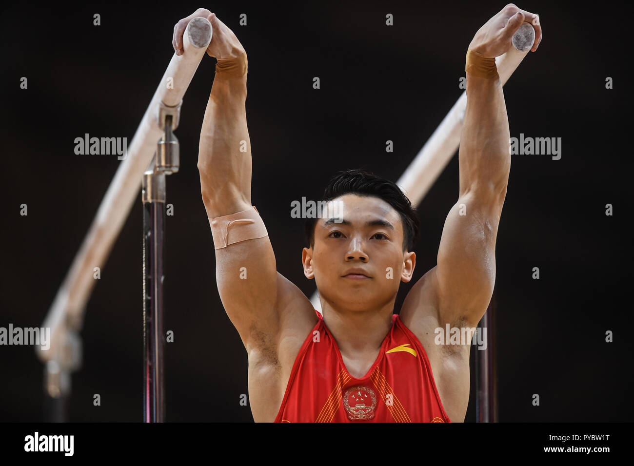 Doha, Qatar. 26th Oct, 2018. ZOU JINGYUAN chalks up the parallel bars ...
