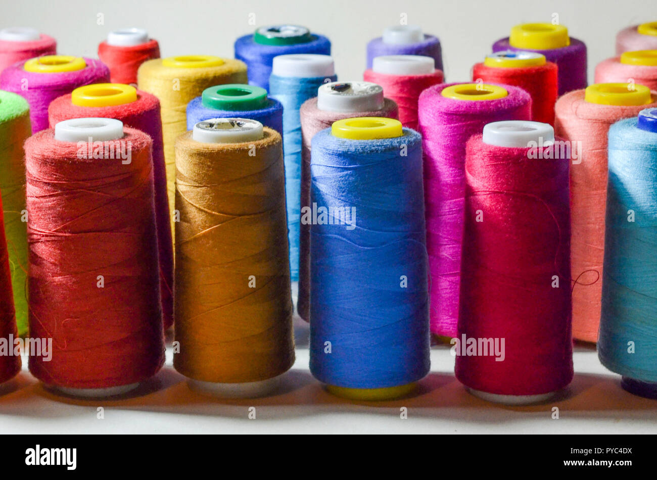 Spools of colours threads isolated on white background Stock Photo - Alamy