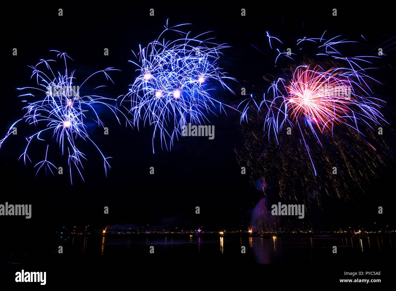 Blue fireballs of exploding fireworks rockets in the sky Stock Photo ...