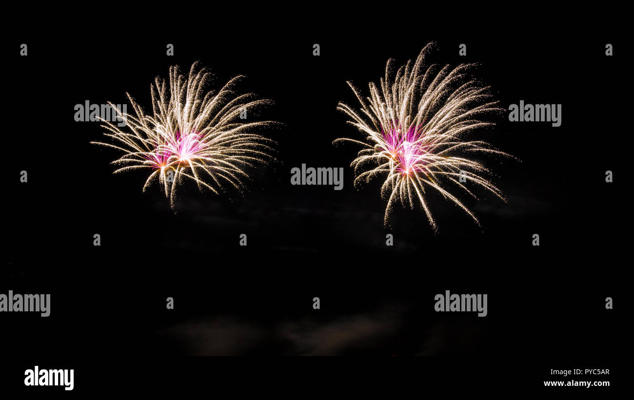 Bright lights of fireworks rocket explosions in dark night sky Stock ...