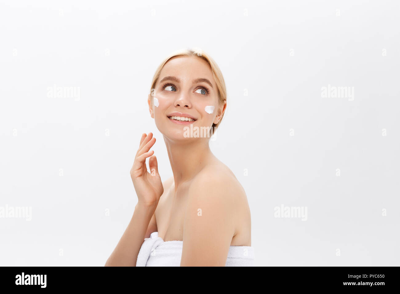 beautiful model applying cosmetic cream treatment on her face on white ...
