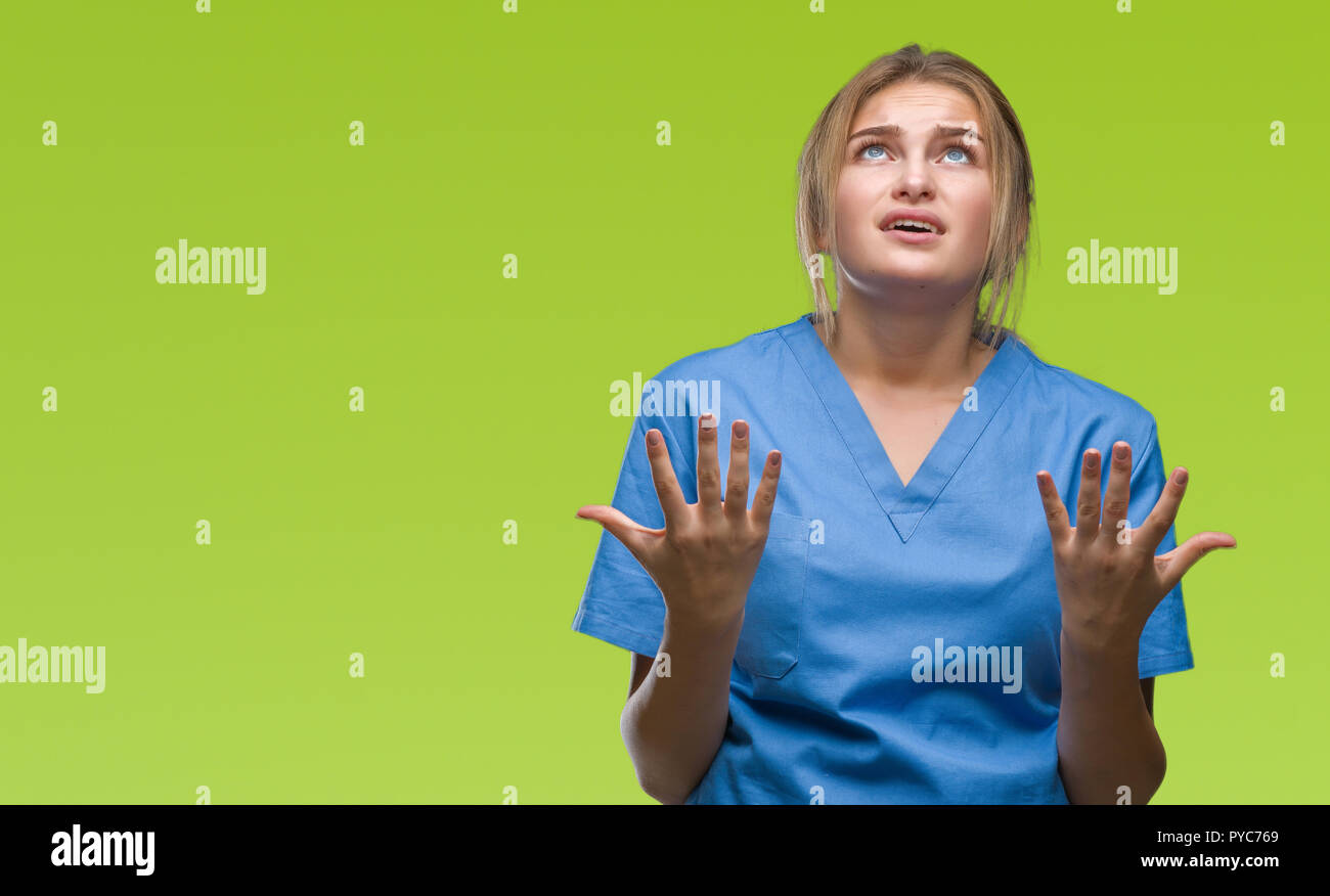 Young caucasian nurse woman wearing surgeon uniform over isolated ...