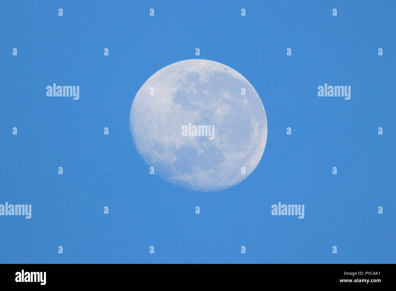 A near full moon with blue sky background Stock Photo - Alamy