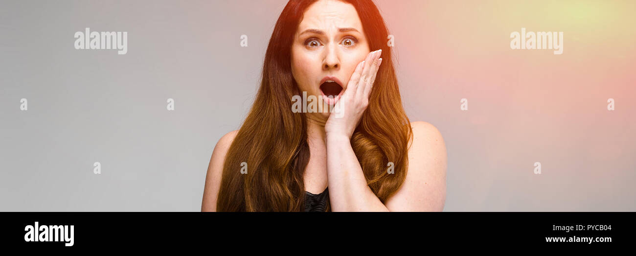 Emotional plus size model standing in studio with open mouth screaming ...