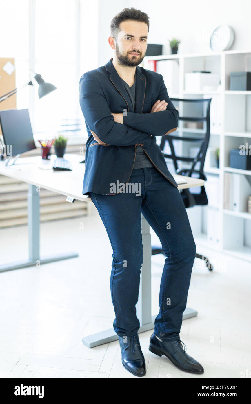 The young man sat down on a table in the office Stock Photo - Alamy