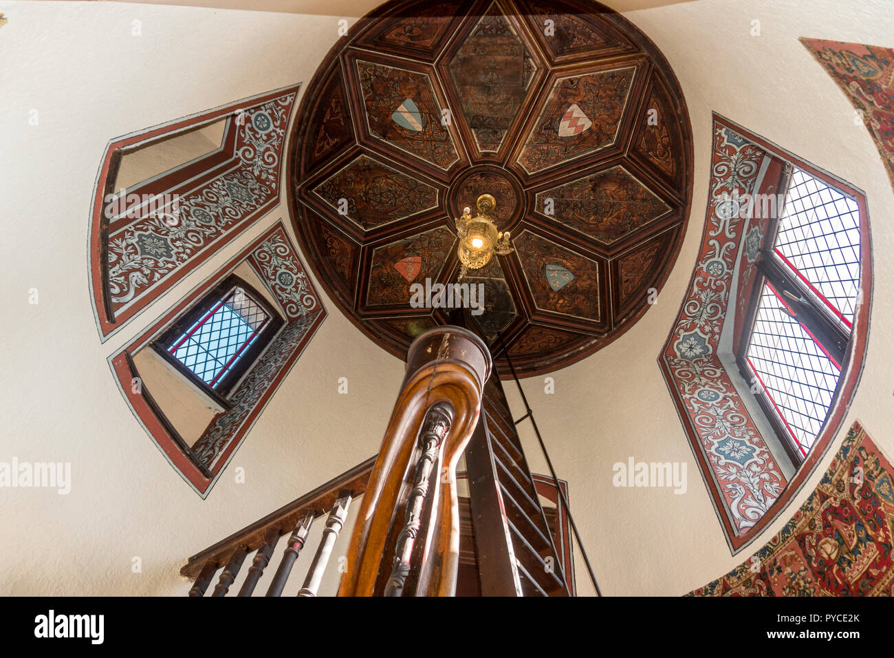 Decorated wooden ceiling and windows of a round castle tower interior ...