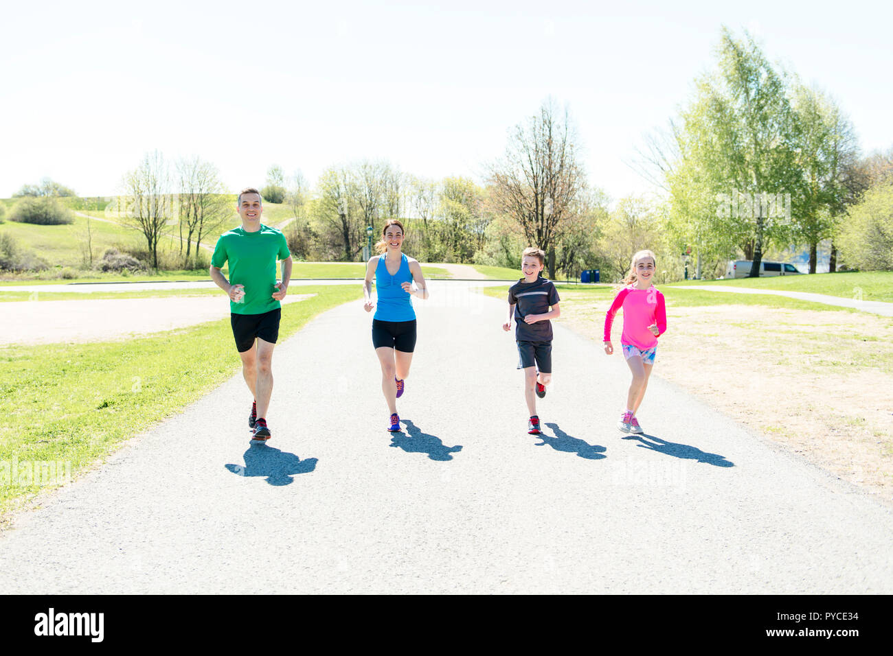 Parents with children sport running together outside Stock Photo - Alamy