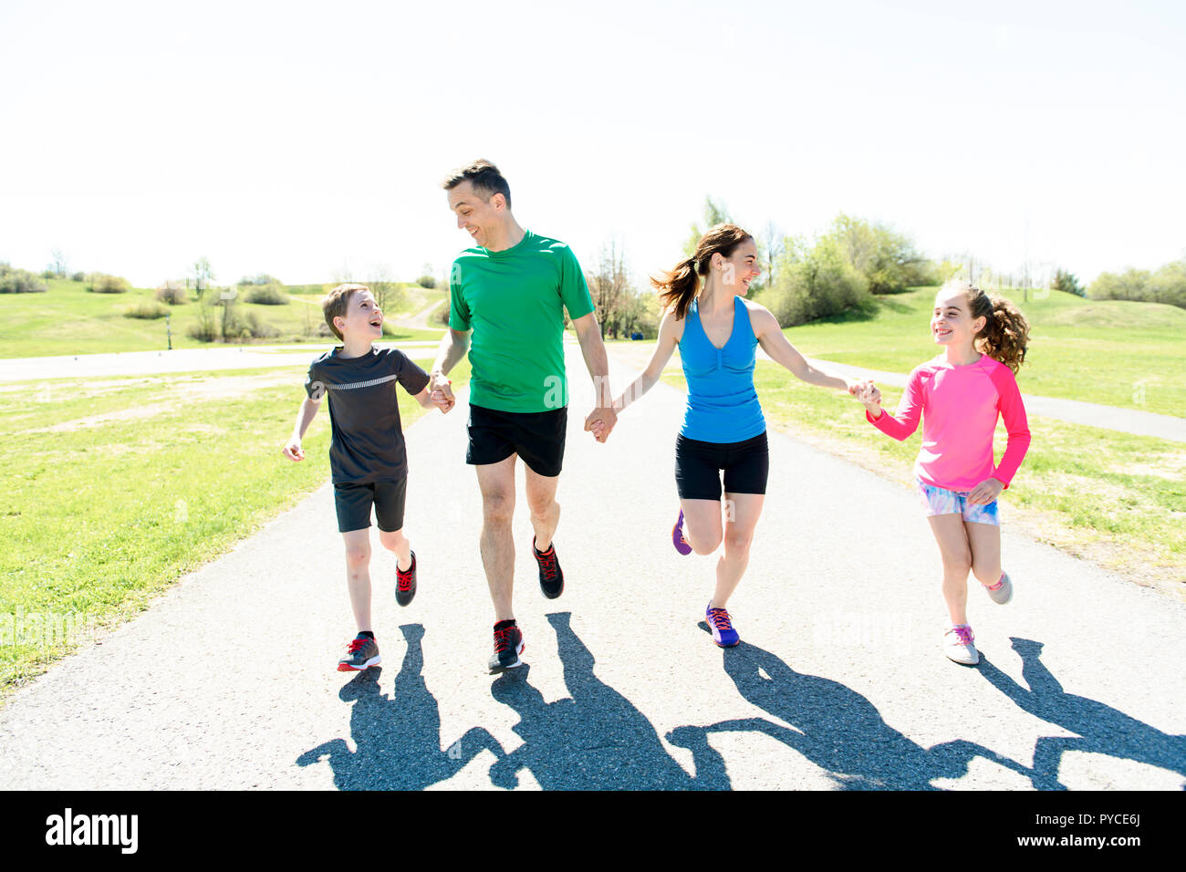 Parents with children sport running together outside Stock Photo - Alamy