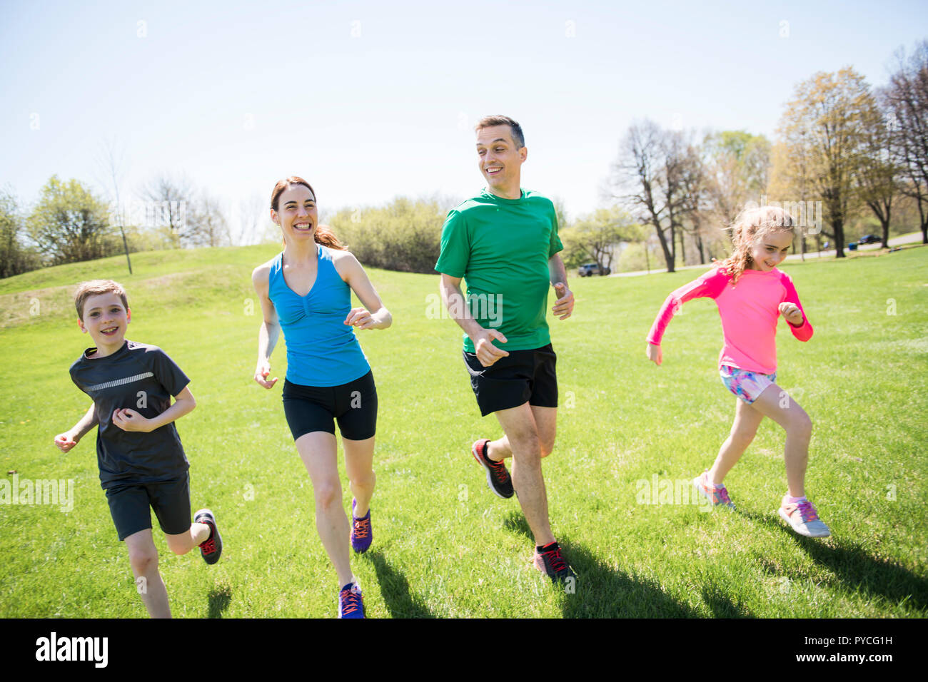 Parents with children sport running together outside Stock Photo - Alamy