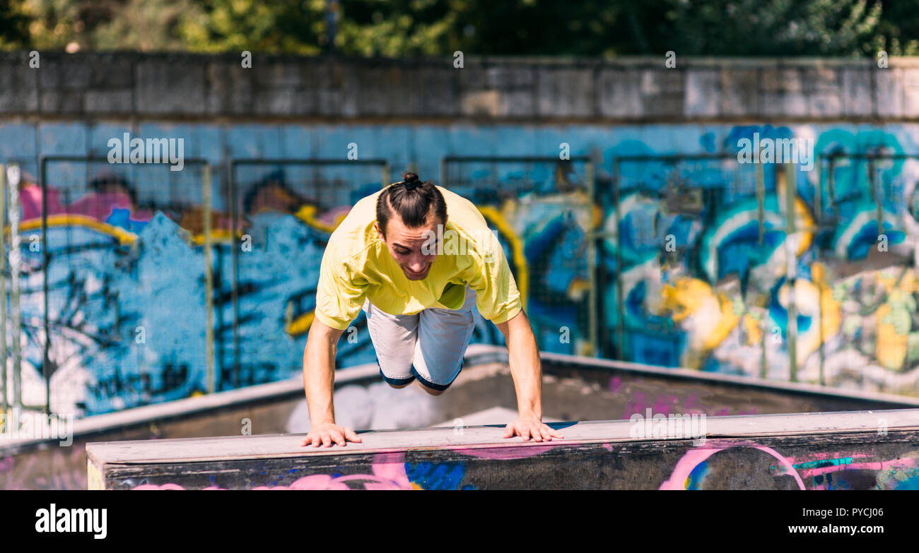Free runner practicing jumping over obstacles in skatepark Stock Photo ...