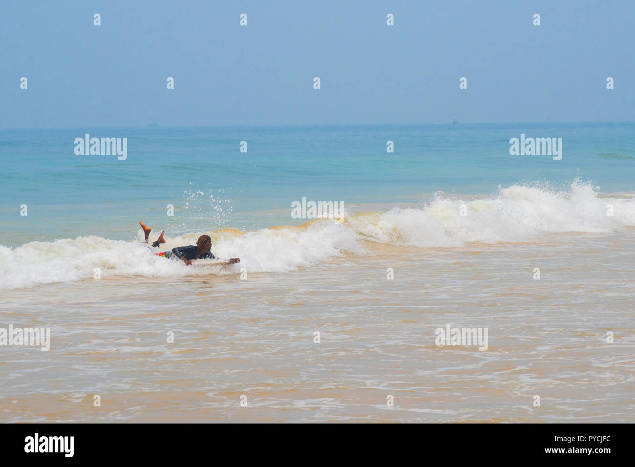 Surfers ride on a wave in the ocean Stock Photo - Alamy