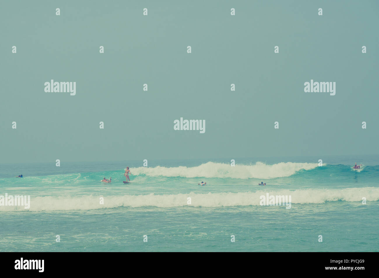 Surfers ride on a wave in the ocean Stock Photo - Alamy