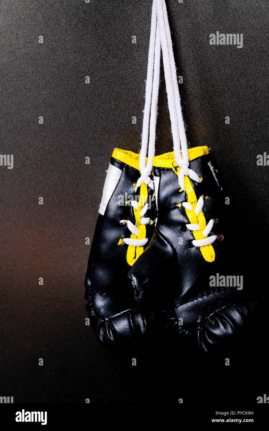 professional black boxing gloves hanging on black background with copy ...
