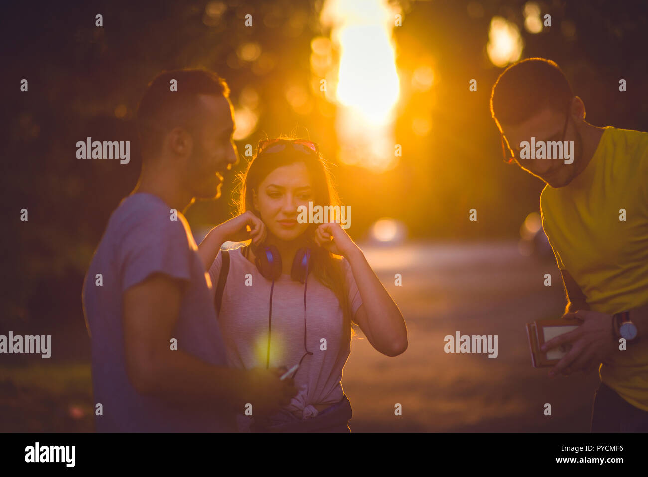 Three friends are talking in the park on beautiful sunset Stock Photo ...