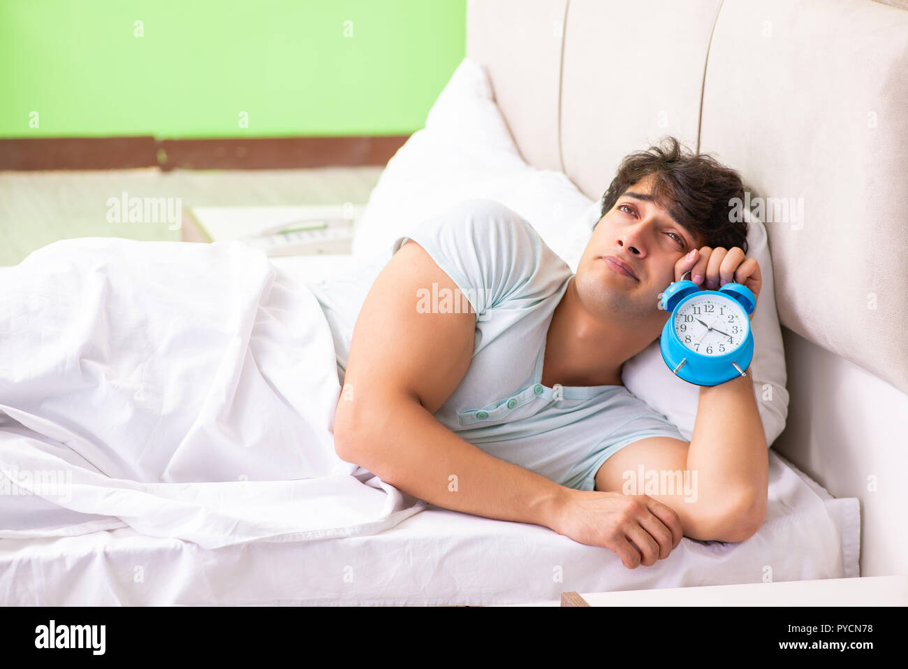 Young man having trouble waking up in early morning Stock Photo - Alamy