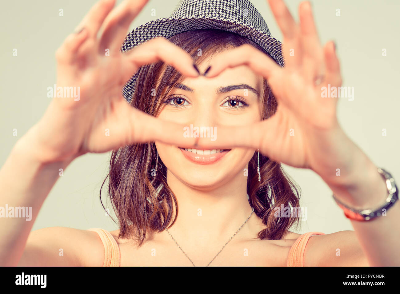 Love. Closeup portrait smiling happy young woman making heart sign ...
