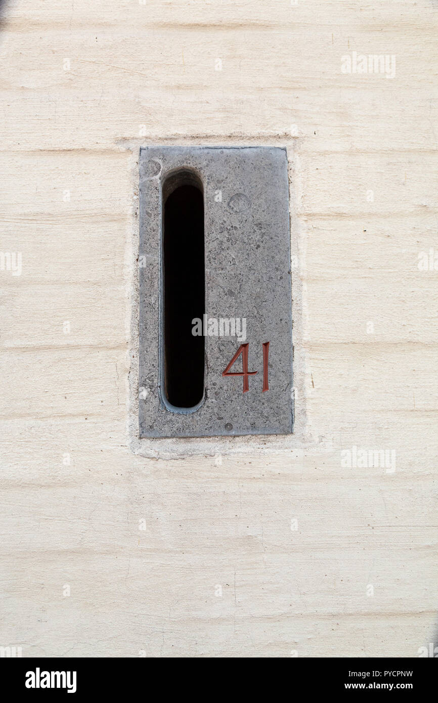 House number forty-one 41 letterbox opening in rendered grey concrete ...