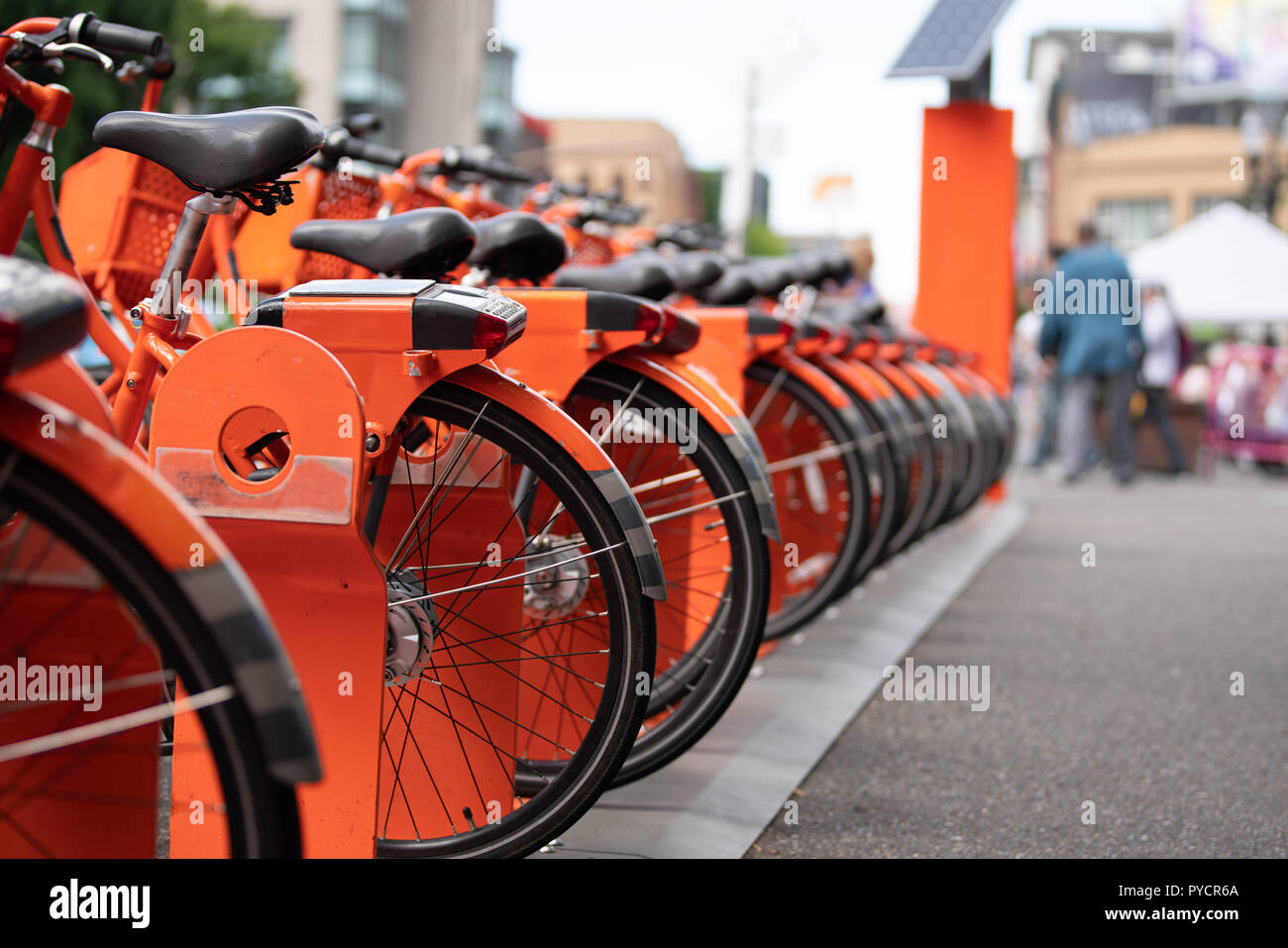 Orange ride sharing bicycles stacked parked in downtown Portland Stock ...
