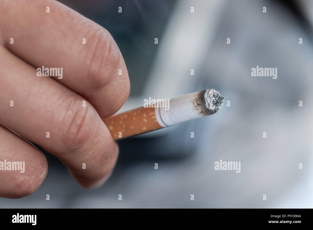 Female hand holding lit cigarette Stock Photo - Alamy