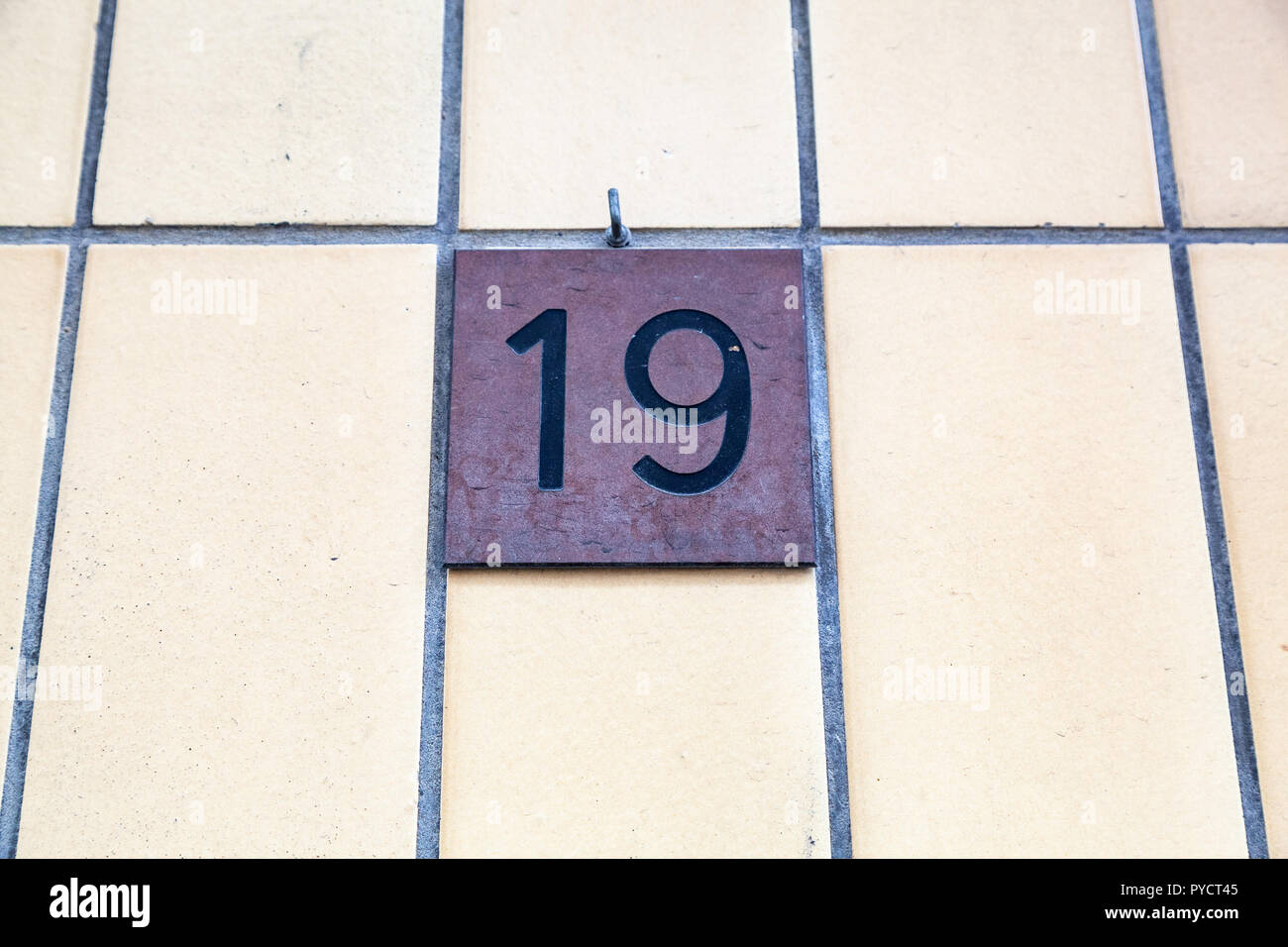 House number nineteen 19 in pressed tarnished and weathered metal ...