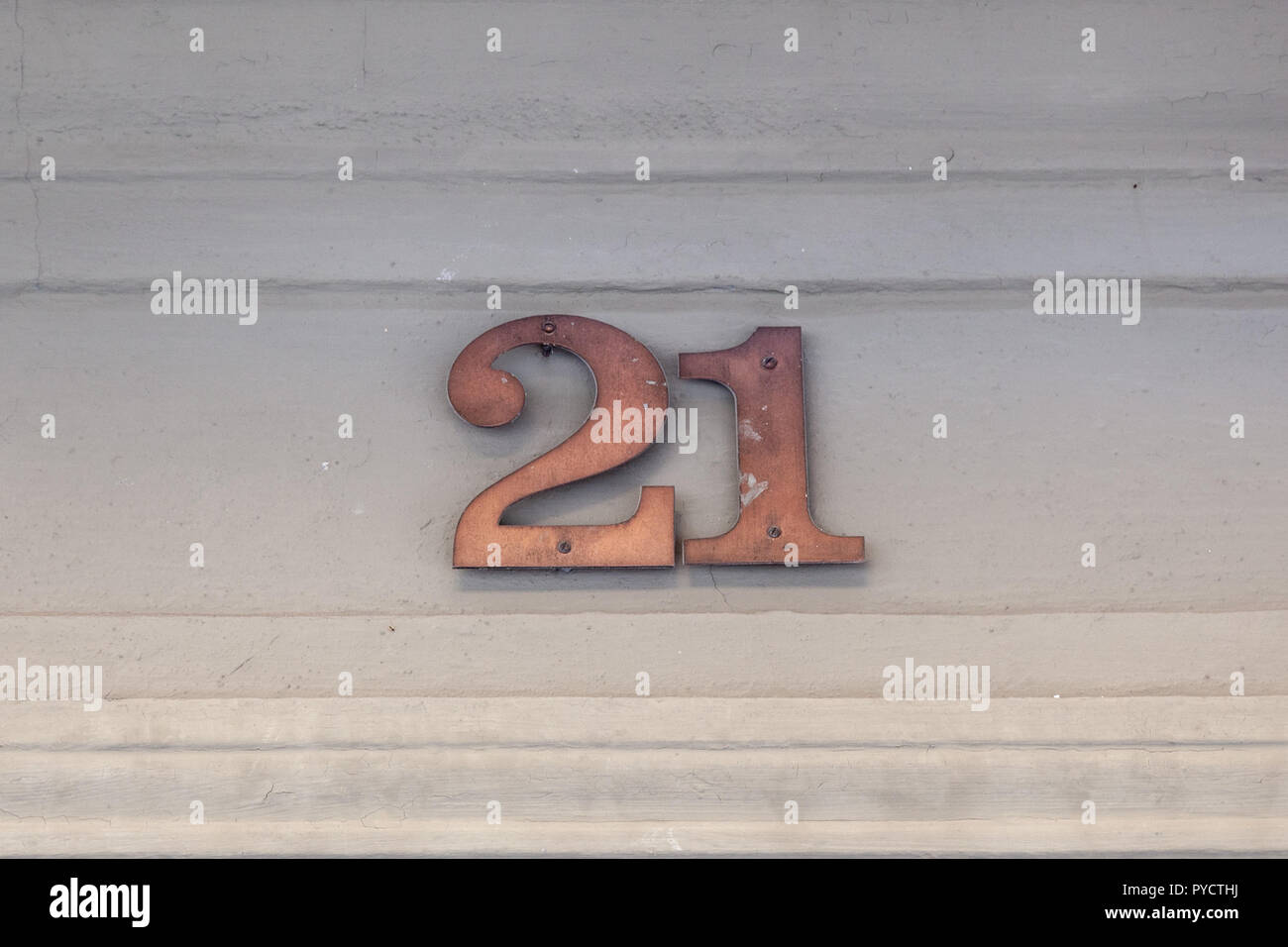 House number twenty-one 21 in cut out metal, painted bronze in designer ...