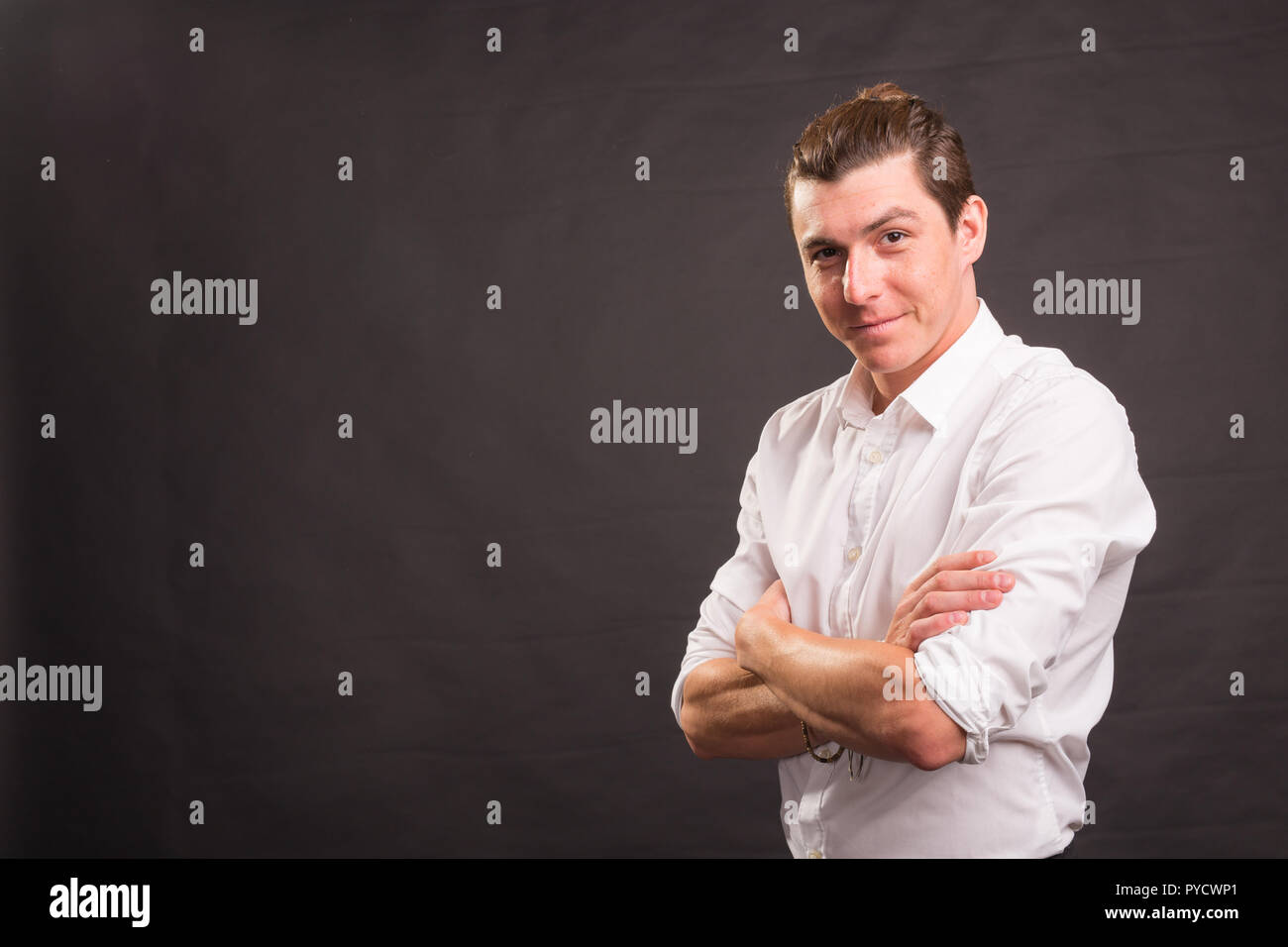 Confident handsome man with crossed arms over gray background with copy ...