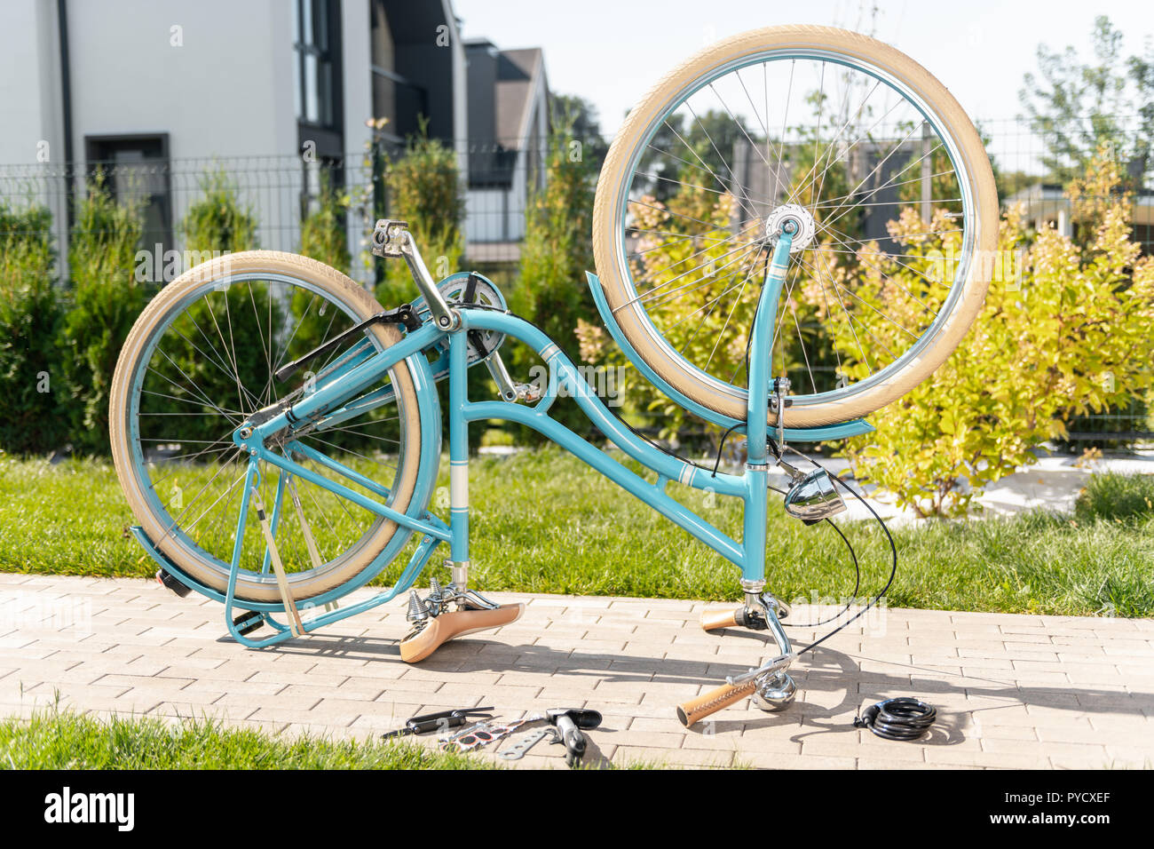 Old-fashioned bright blue bicycle standing on the floor near summer ...